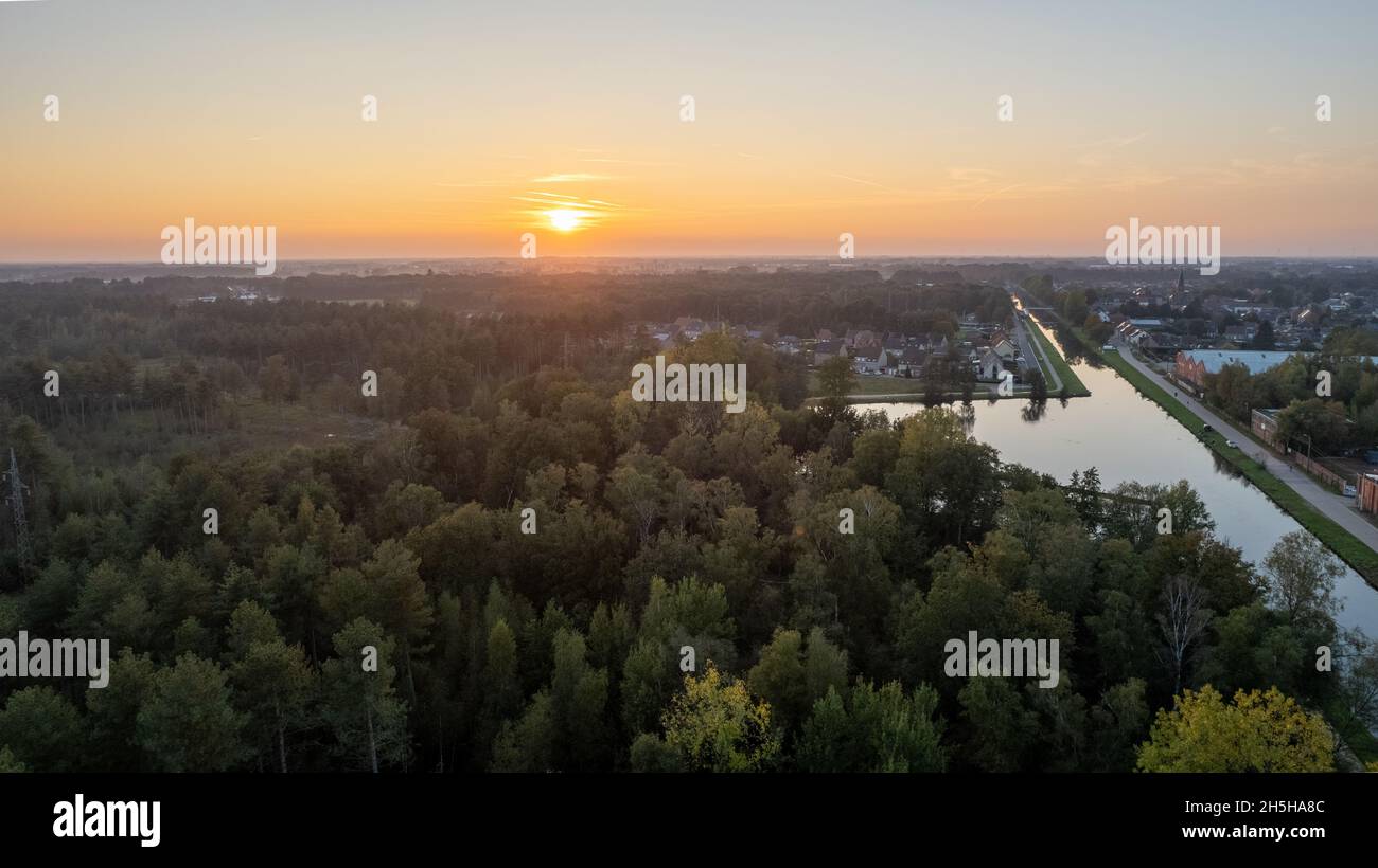 Beautiful sunset over a river with green bushes and color rich sky ...
