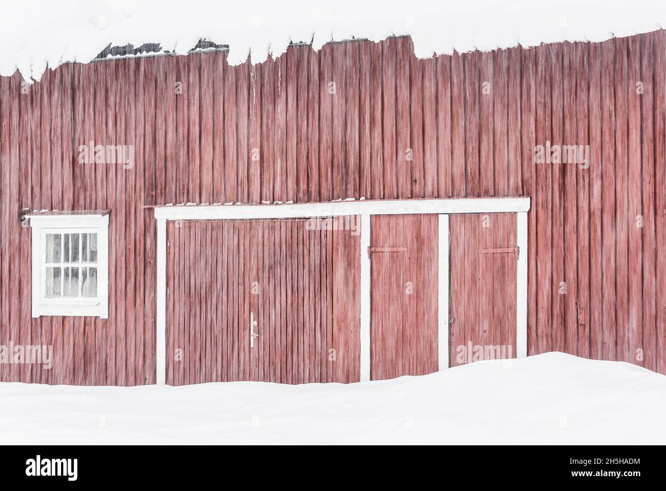 Snowfall in front of red farm building Stock Photo - Alamy