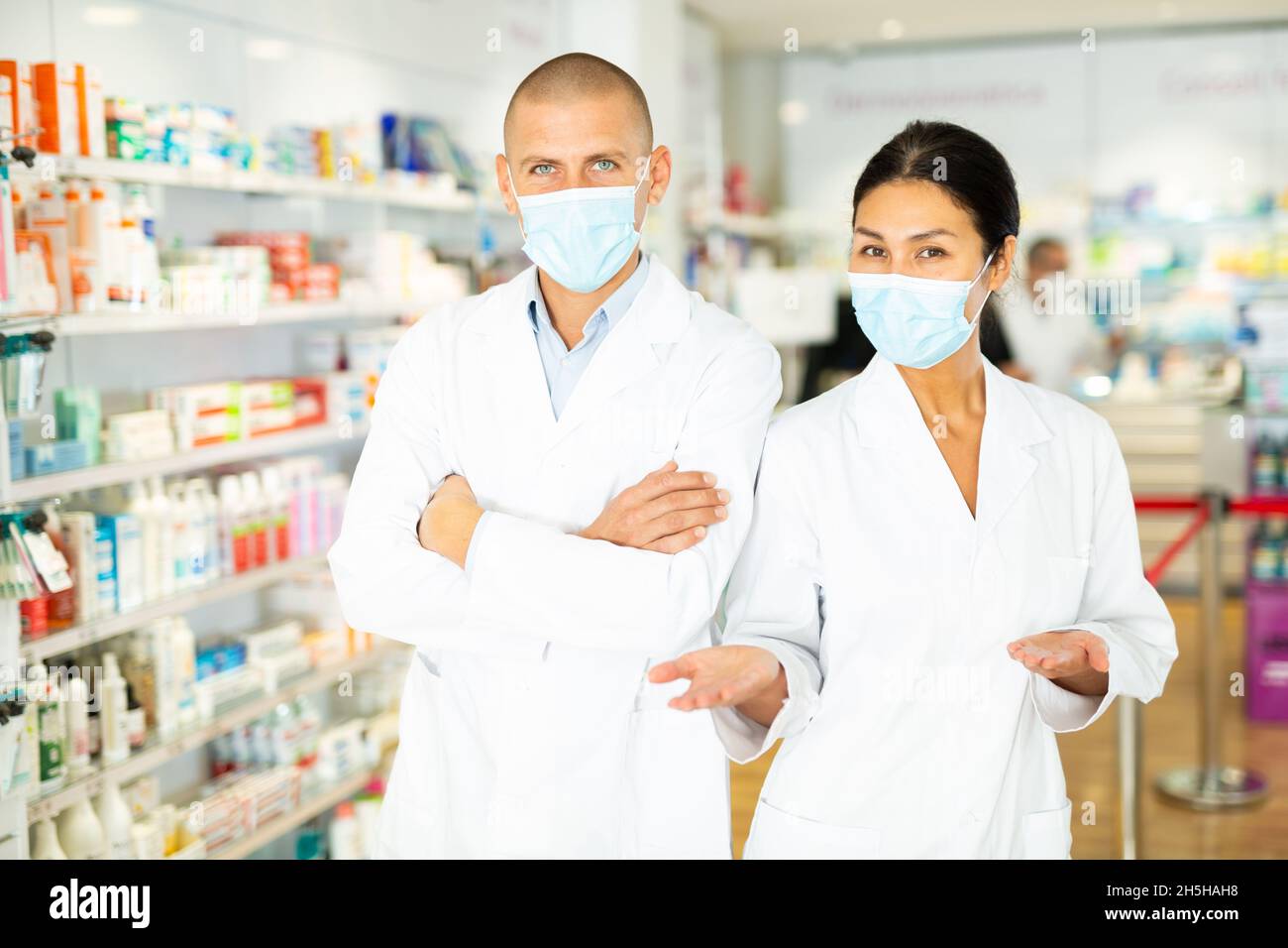 Portrait of two pharmacists in medical masks and white coats in ...