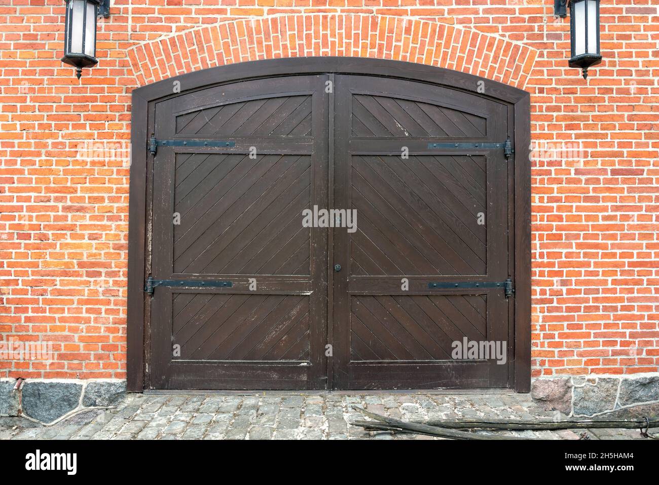 Black wooden, old gate in a brick wall. Vintage wooden gate effect ...