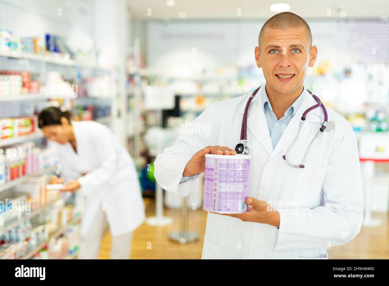 Male pharmacist offers medicine while standing in the trading floor of ...