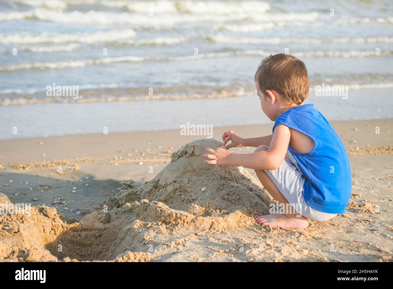 Boy building sandcastle on beach hi-res stock photography and images ...