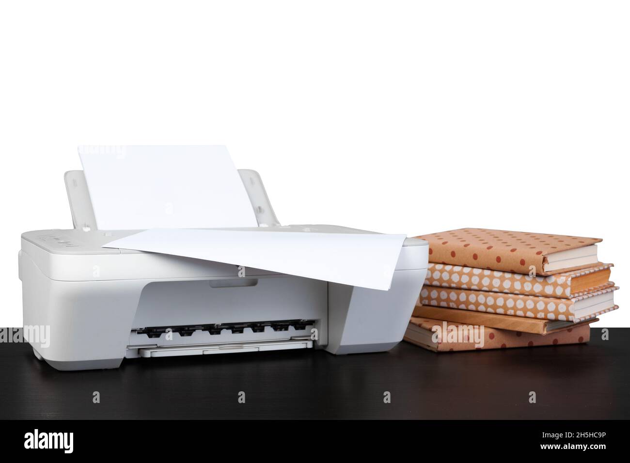 Printer and stack of books on black table against white background ...