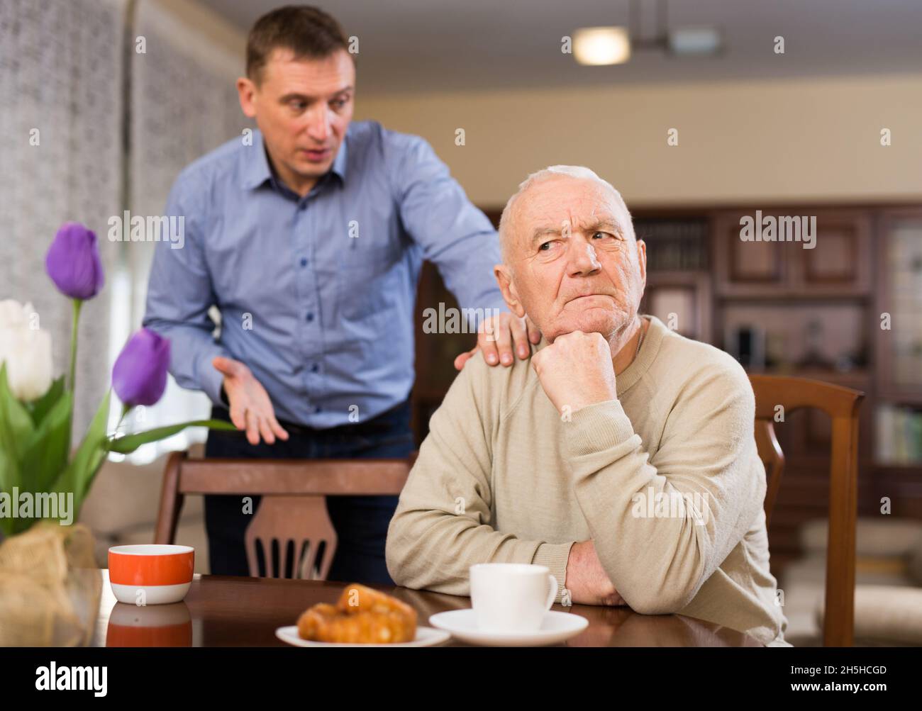 Adult son apologizing to offended father Stock Photo - Alamy