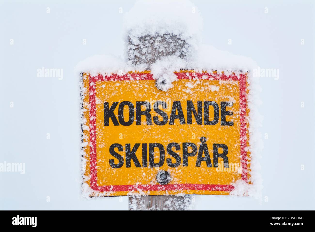 Snow covered warning sign for crossing ski tracks Stock Photo - Alamy