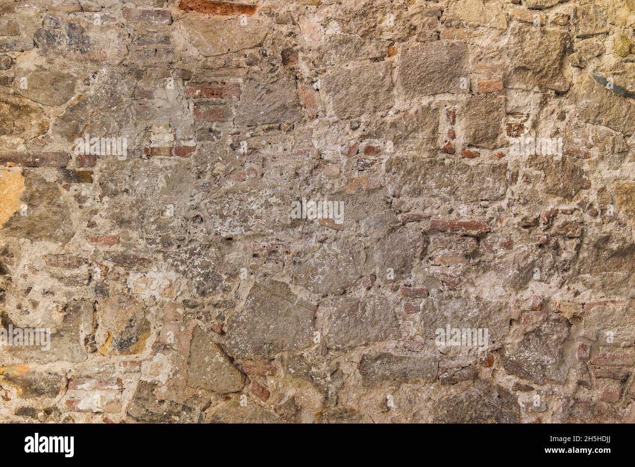 Fragment of old stone wall. Multicolored large cobbles. Old medieval ...