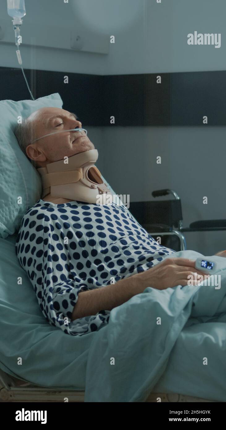 Old patient with cervical neck collar laying in hospital ward bed at ...