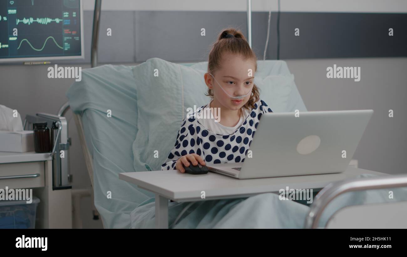 Hospitalized sick girl playing online videogames using laptop computer ...