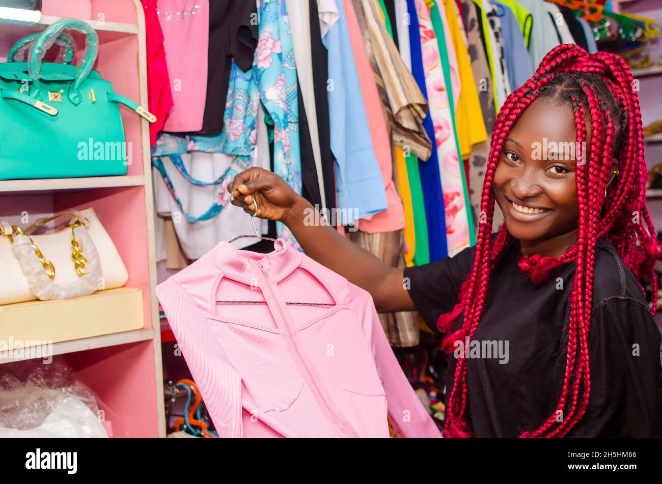 beautiful young african woman smiling as she is shopping for clothes in ...