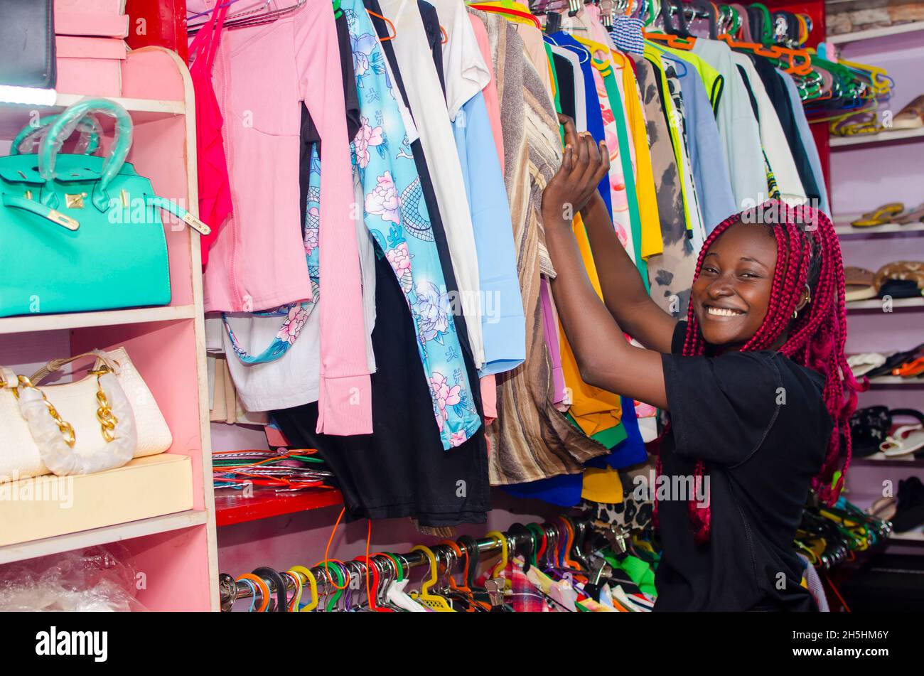 Beautiful woman checking Multi-coloured wardrobe showcase and smiling ...
