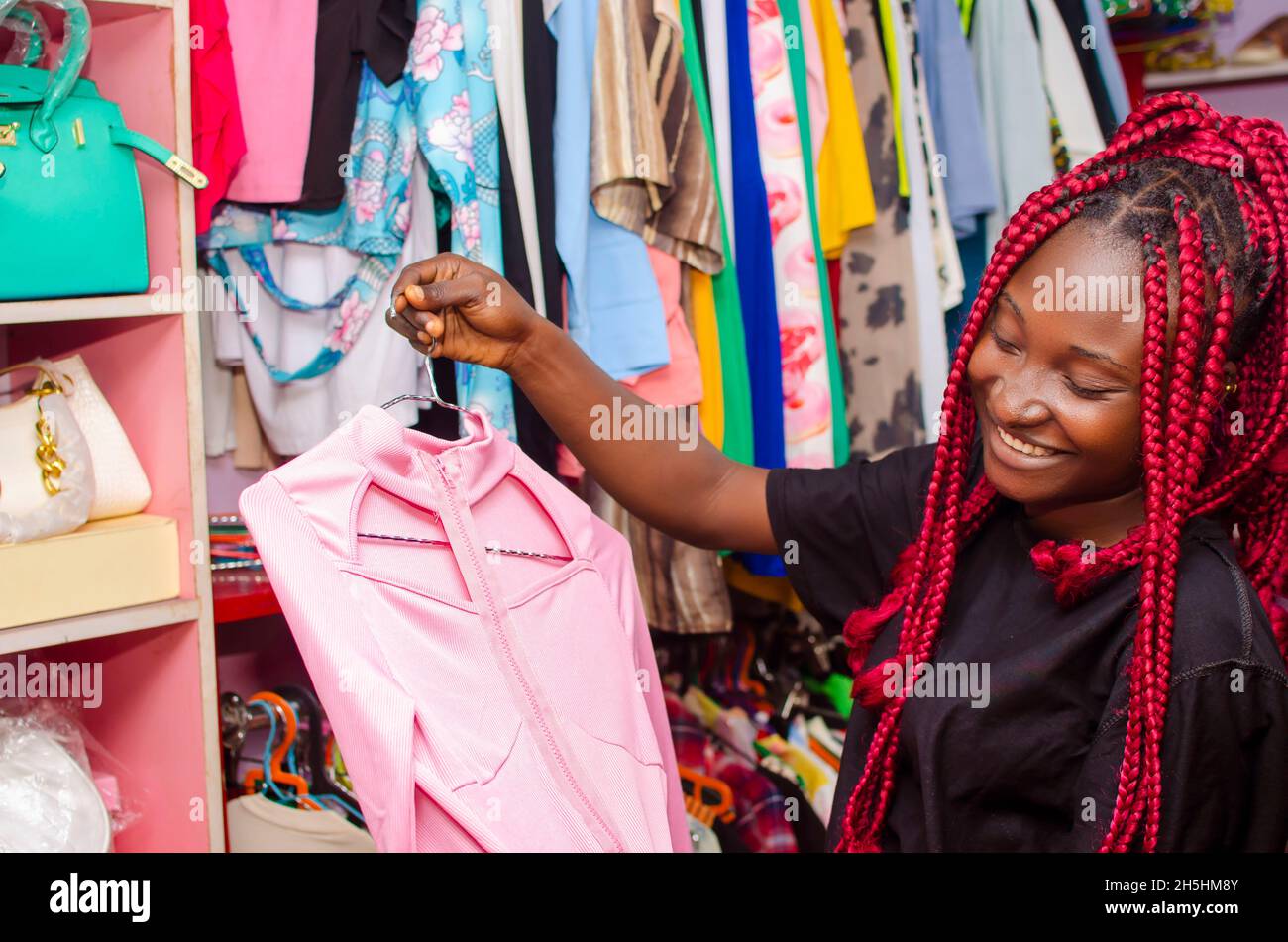 beautiful young african woman shopping for clothes in store Stock Photo ...