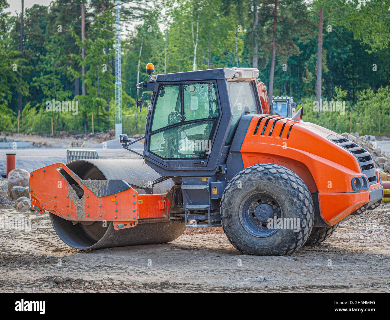 Road construction. Large rolling machinery paving a road to a distant ...