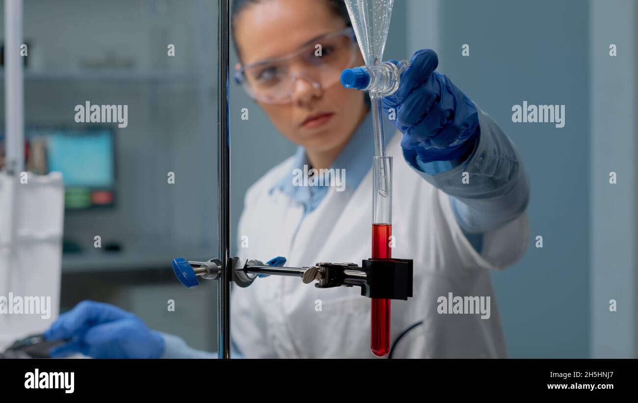 Close up of scientist using laboratory glassware on desk for medical ...