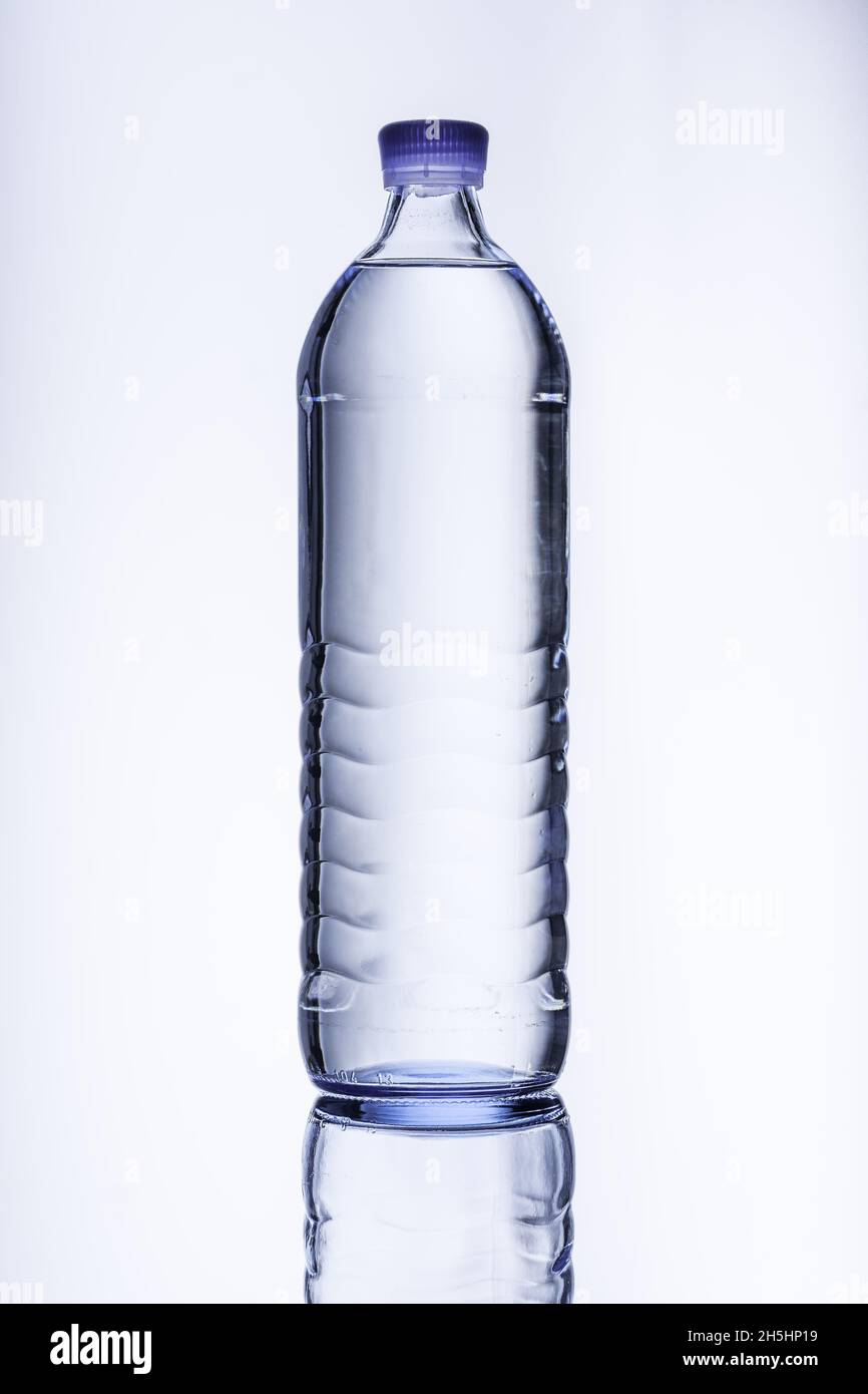 Vertical shot of a plastic bottle with water in the white background ...