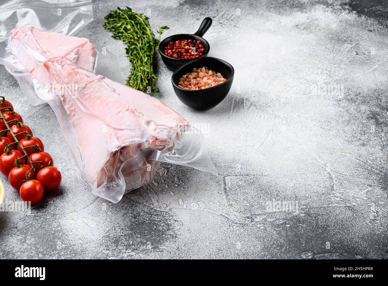 Red perch frozen pack fish meat set, with herbs, on gray stone table ...