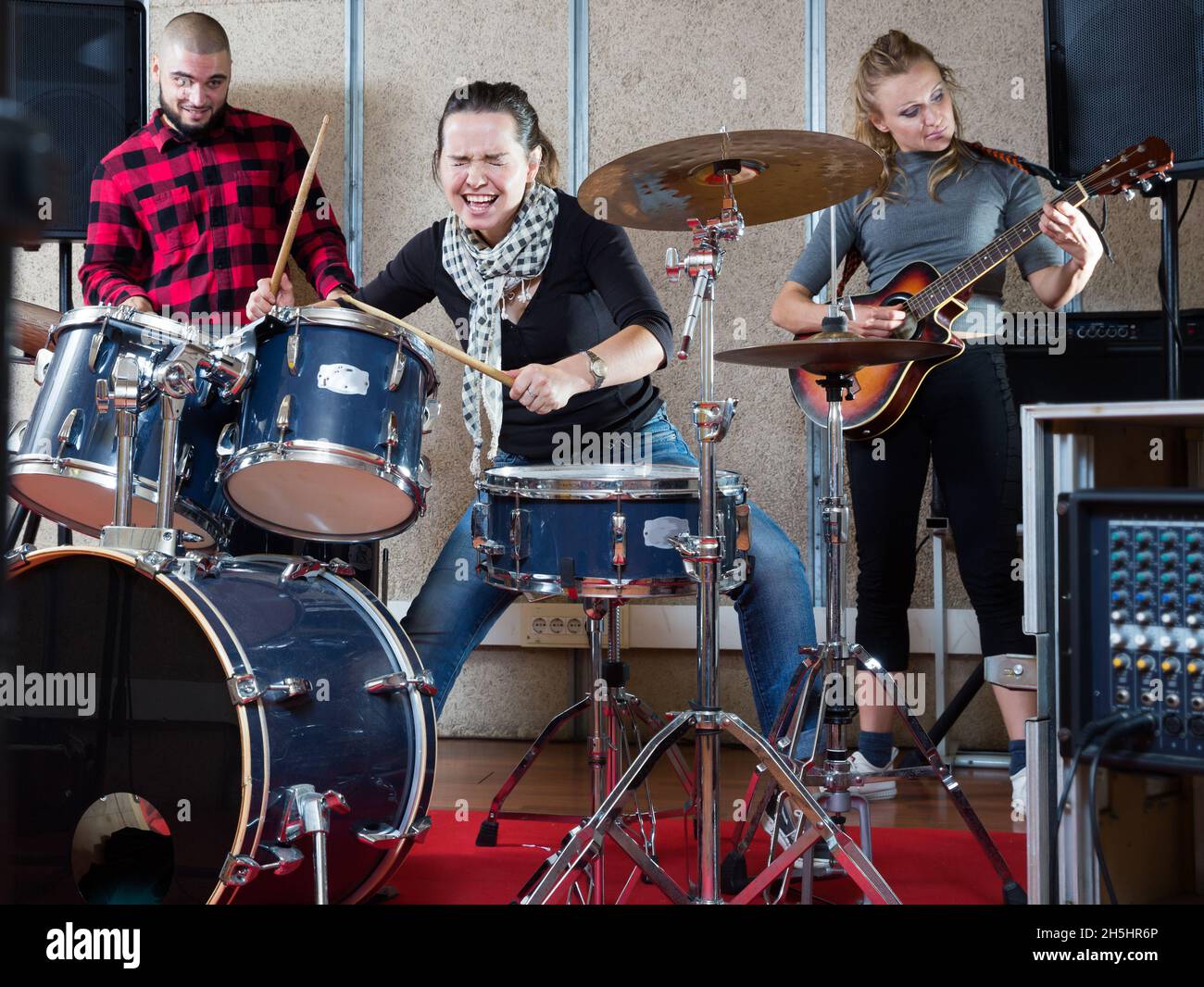 Music band with pretty girl drummer rehearsing Stock Photo - Alamy