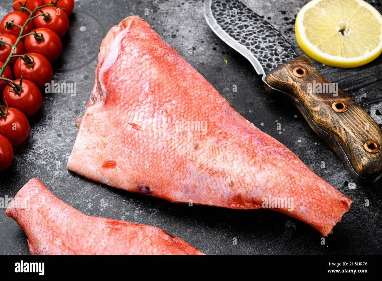 Fresh red perch or sea bass set, on black dark stone table background ...