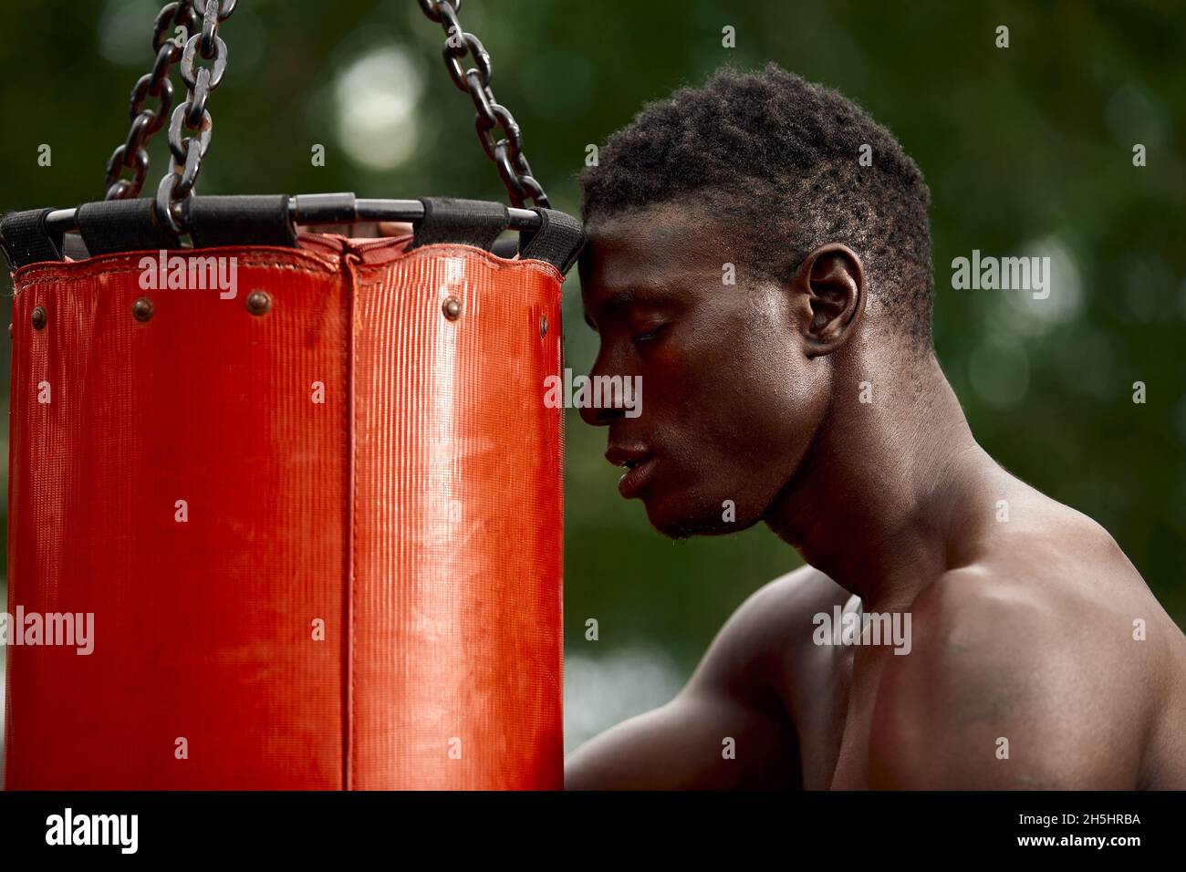 Front view of muscular black boxer punching towards camera with a deep ...