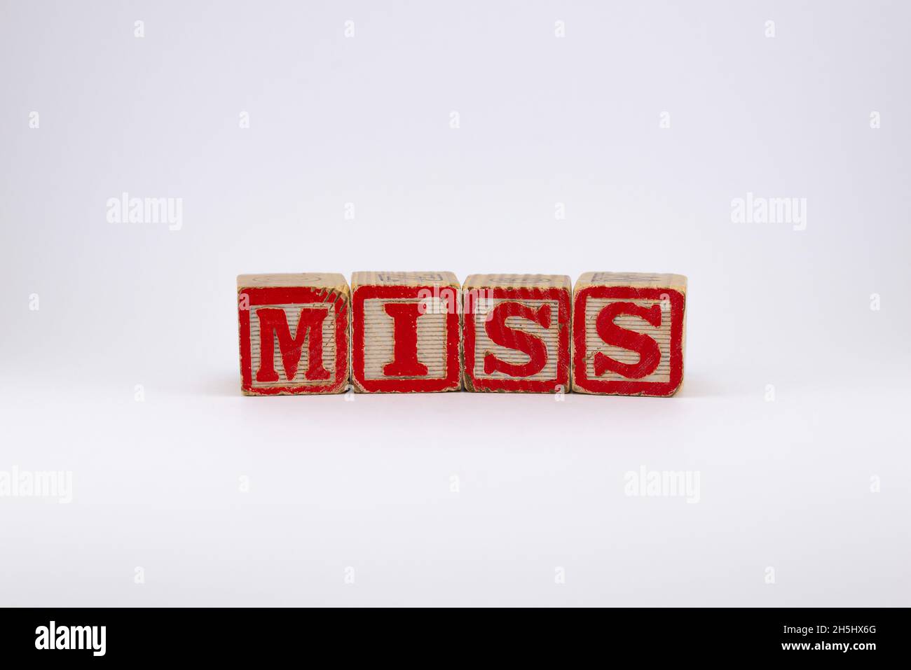A symbol of miss in wooden cubes on white background Stock Photo - Alamy