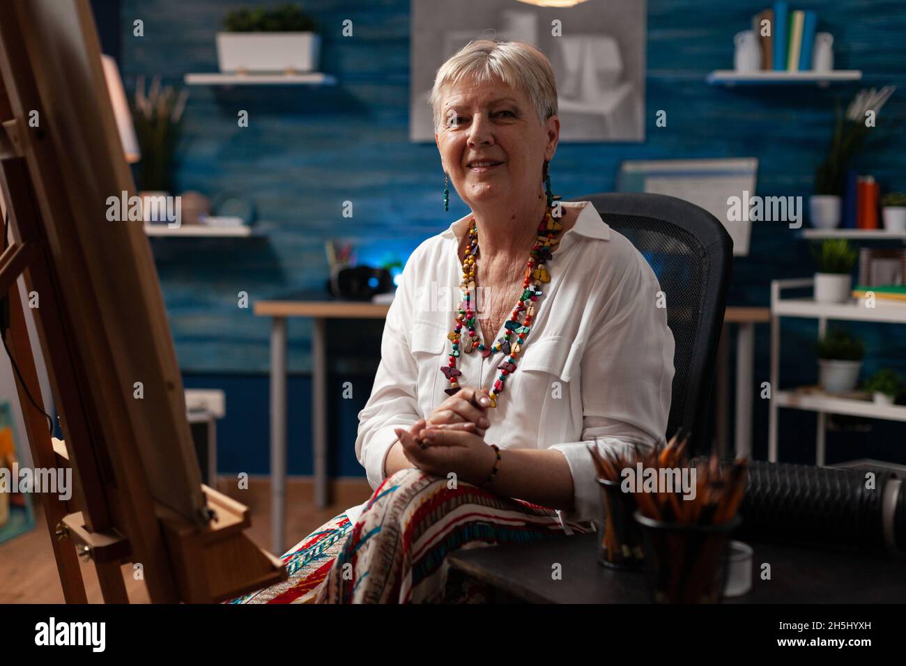 Elder person prepared to draw on canvas for art project while sitting ...