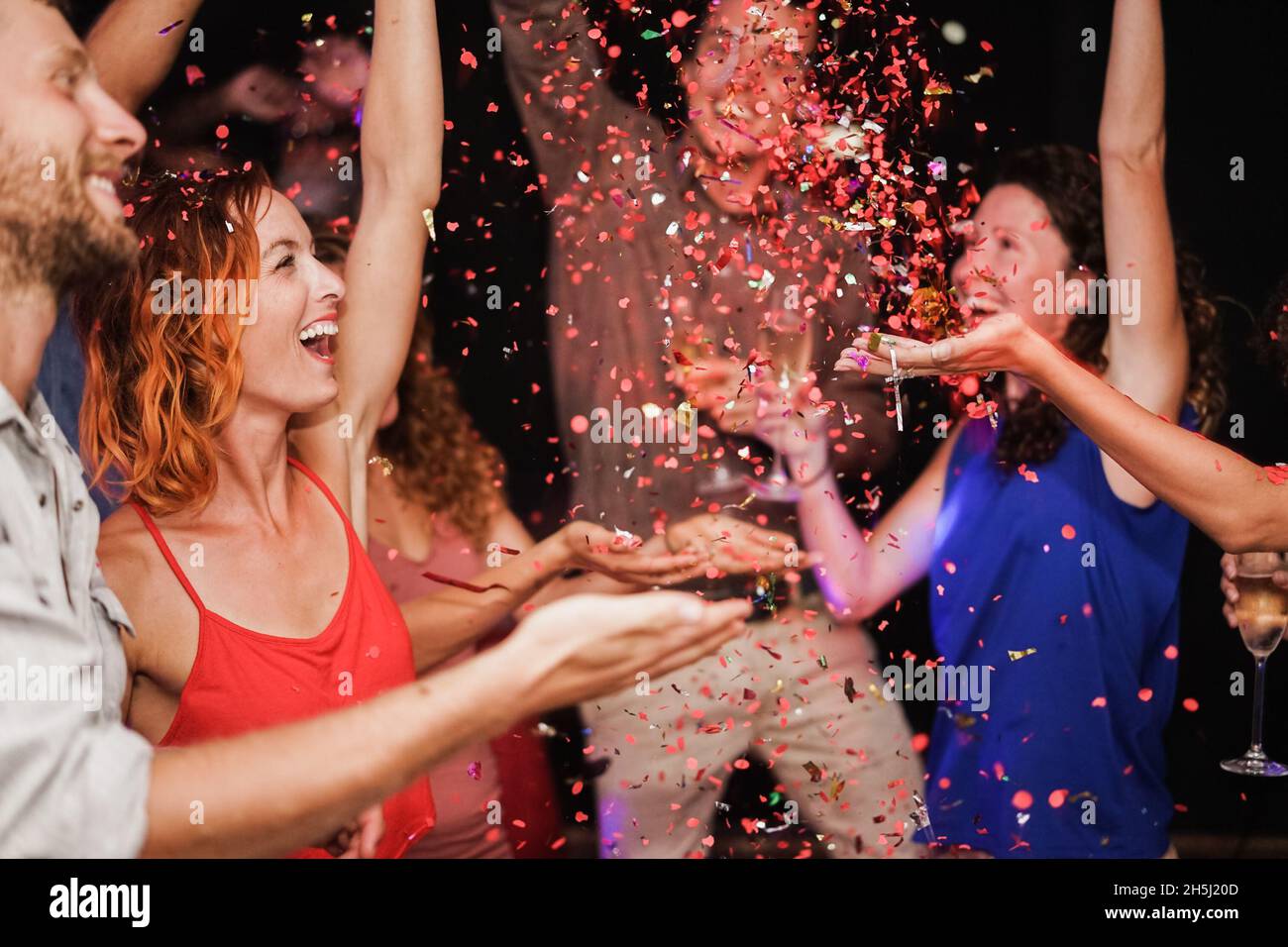 Young friends celebrating together with confetti at party night club ...