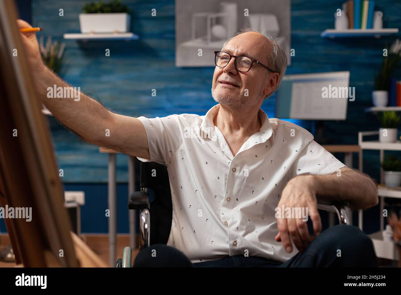 Portrait of disabled artist using pencil on canvas for professional ...