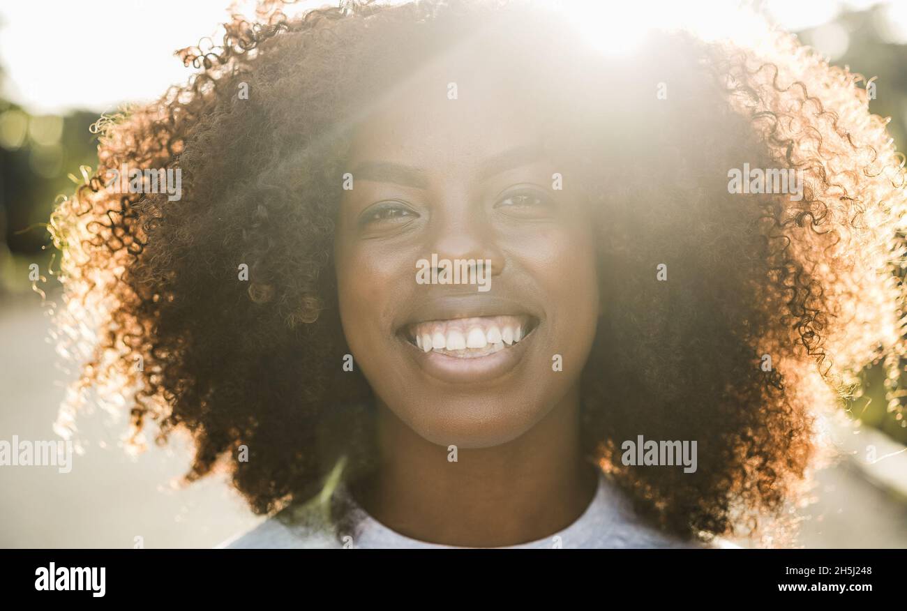 Young african girl smiling on camera outdoor in the city - Focus on ...