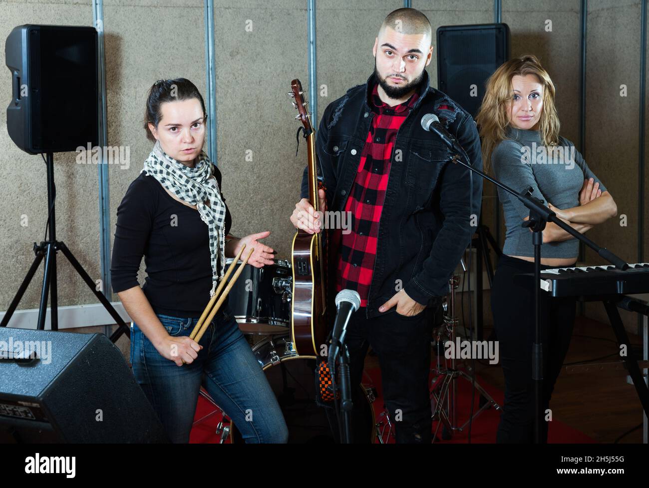 expressive group of rock musicians posing with instruments Stock Photo ...