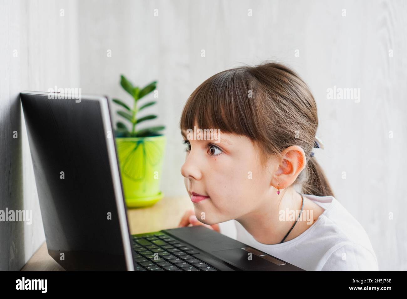 Indoor shot of cute dark haired female child looking at notebook very ...