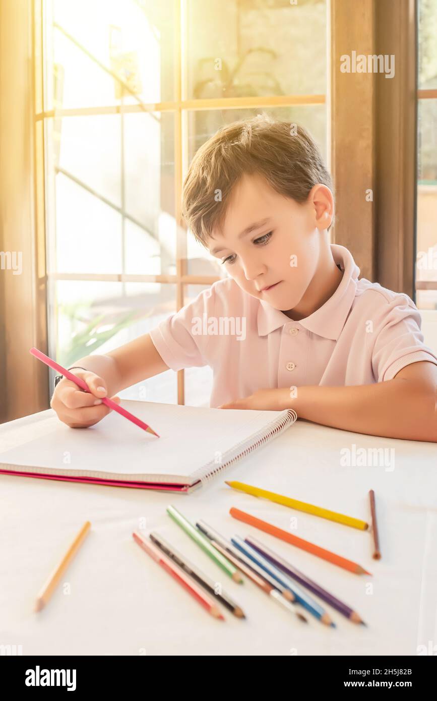 A child doing homework at home, drawing with crayons Stock Photo - Alamy