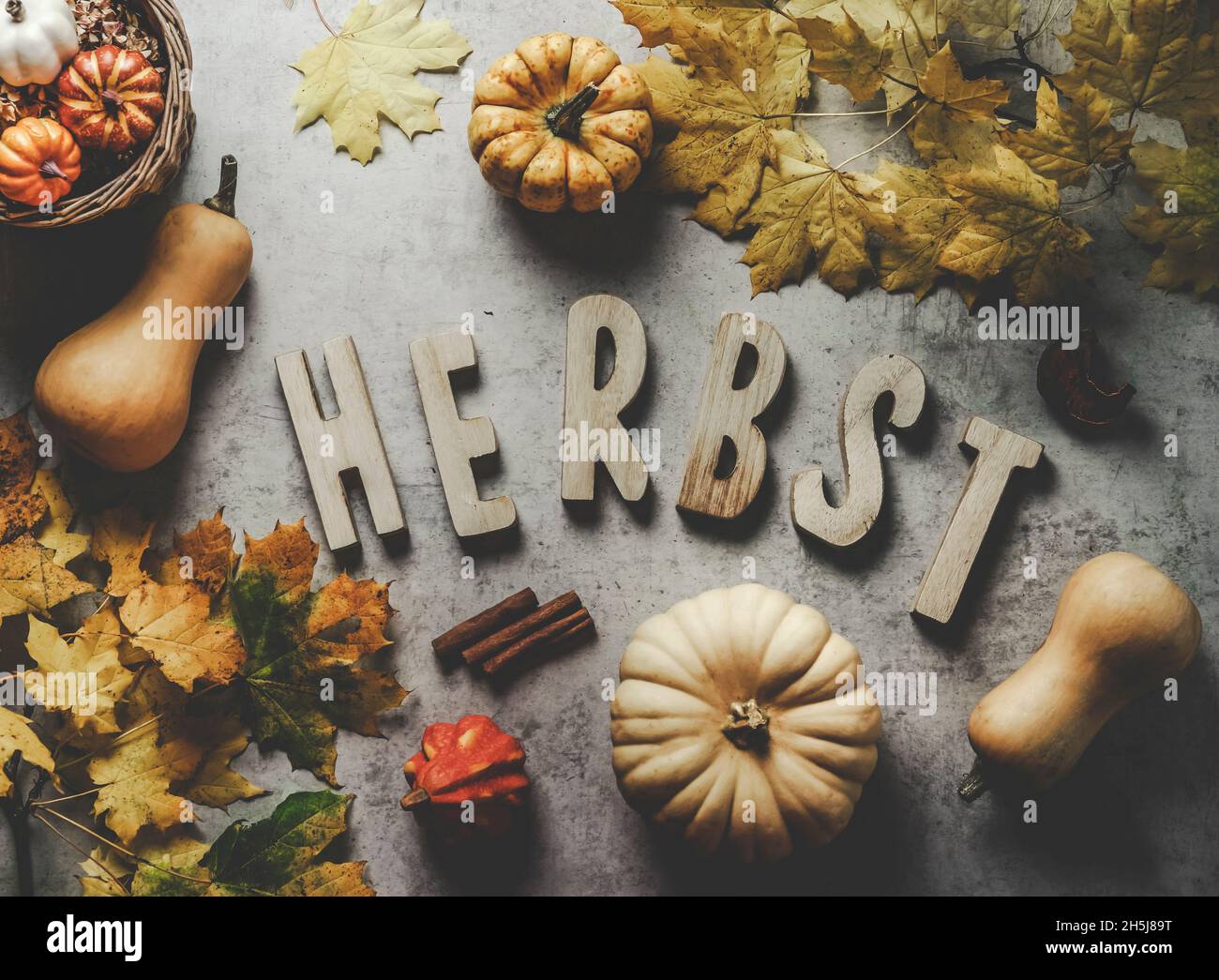 Autumn background with German word herbst, autumn leaves, pumpkins ...