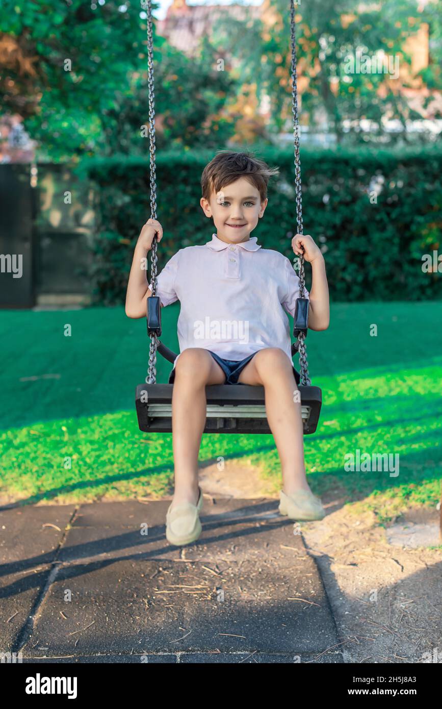Front view of a child playing on a swing in a playground Stock Photo ...