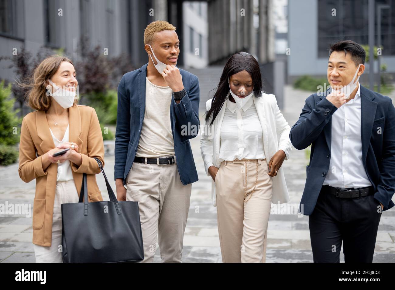 Business team taking off medical masks and talking Stock Photo - Alamy