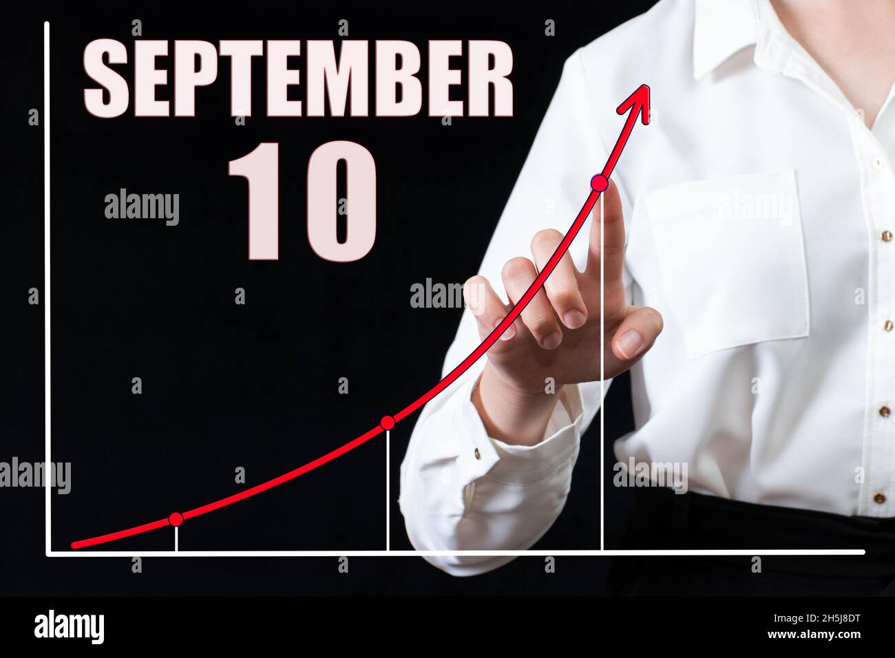 10th day of september. Businesswoman's hand pointing to the graph and a ...