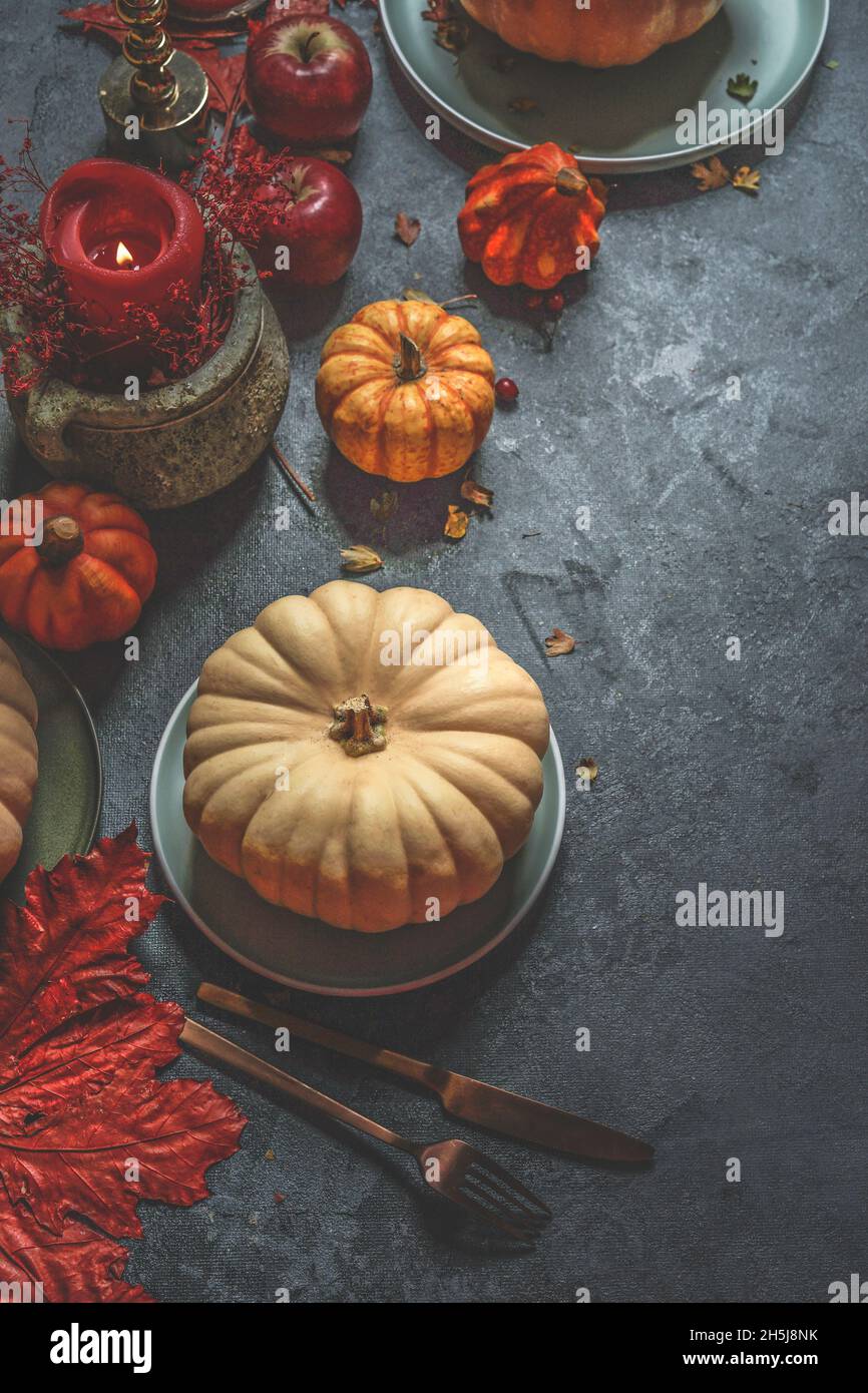 Autumn background with white pumpkin, plates, fall leaves and cutlery ...
