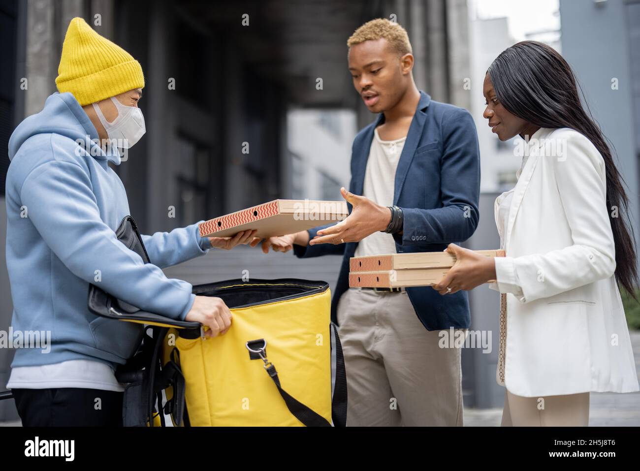 Courier giving food order to business people Stock Photo - Alamy