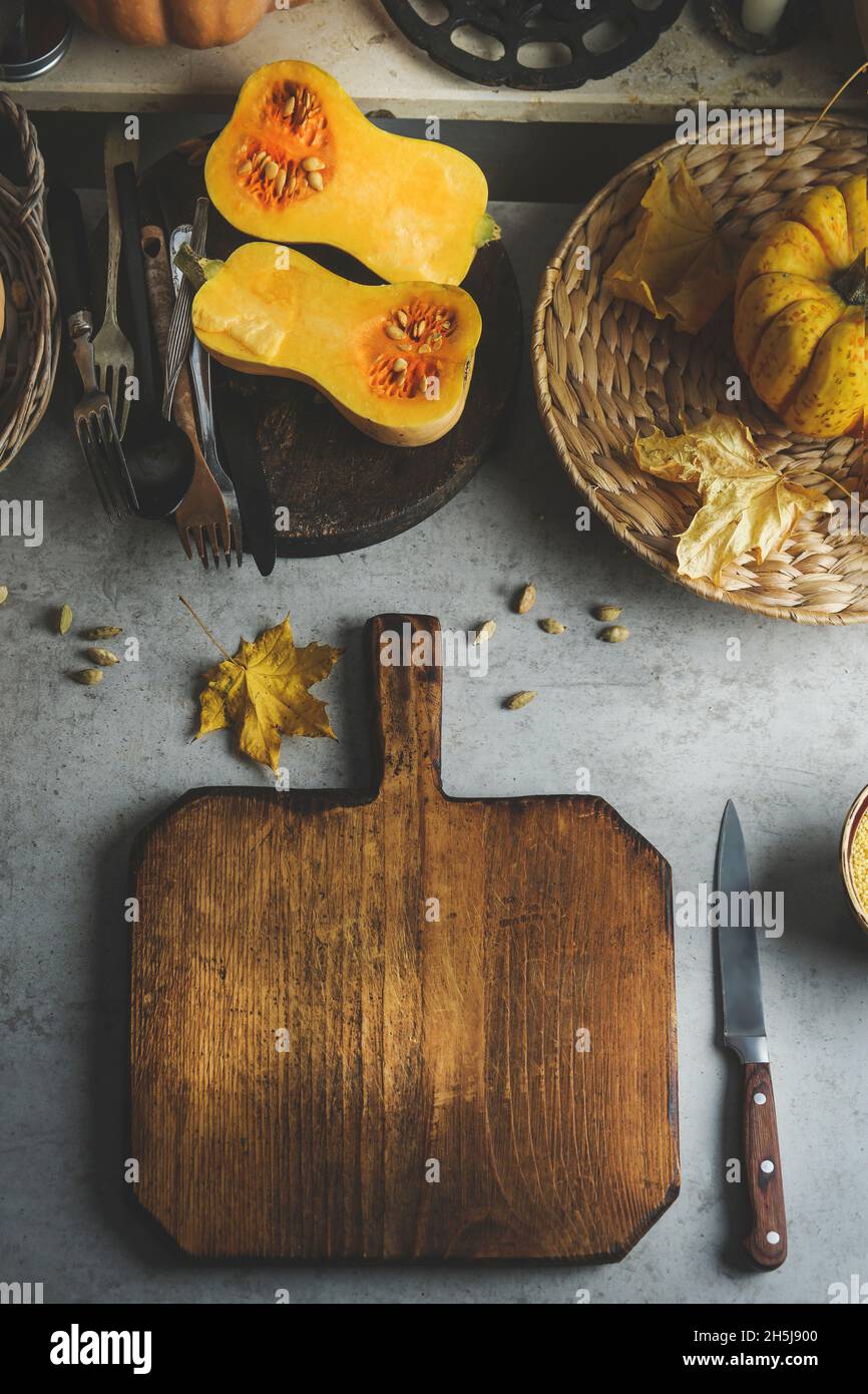 Food background with empty wooden cutting board on kitchen table with ...
