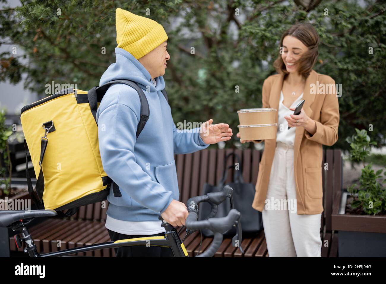 Courier giving food order to business people Stock Photo - Alamy
