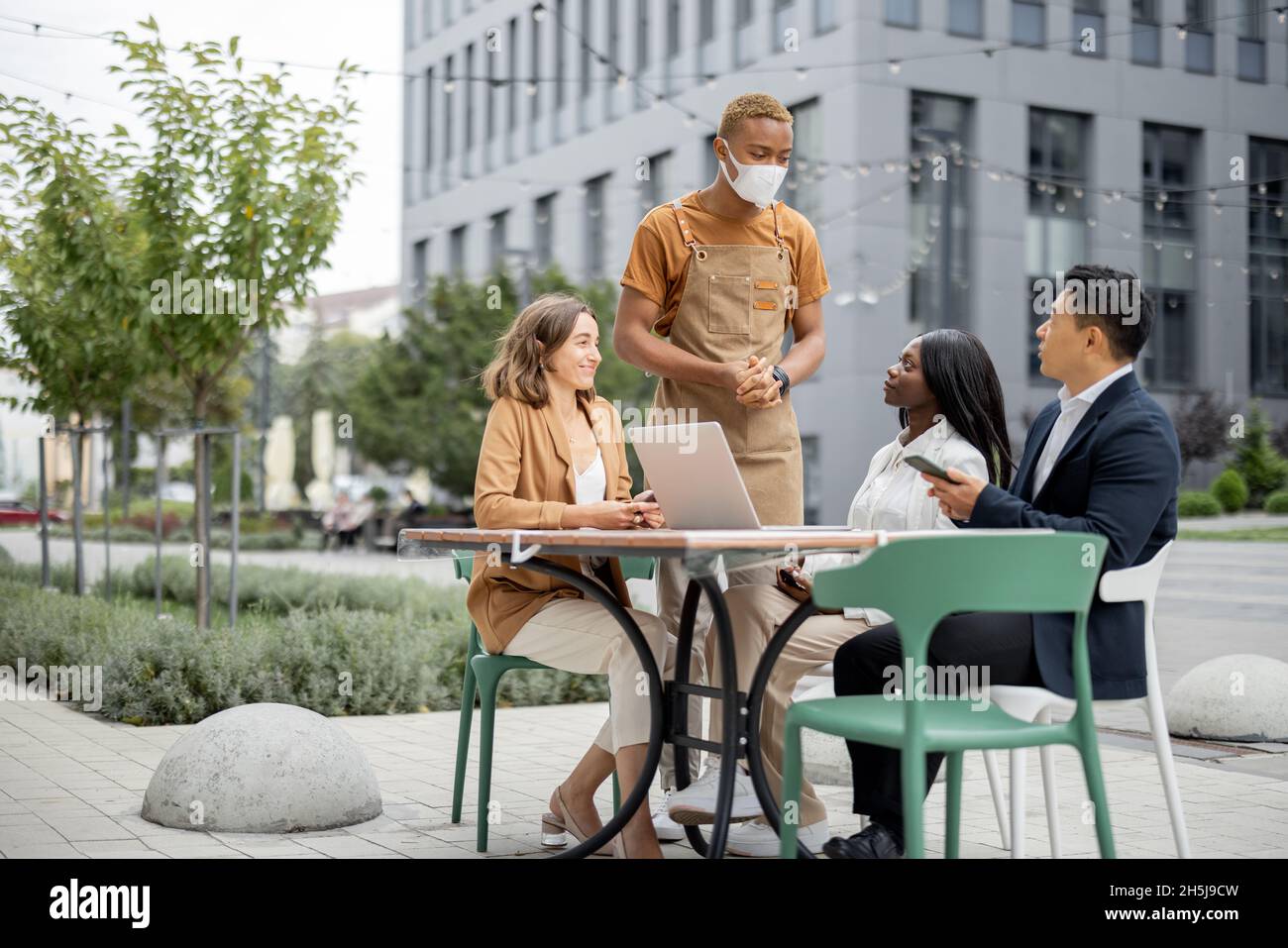 Waiter taking order from client at outdoor cafe Stock Photo - Alamy