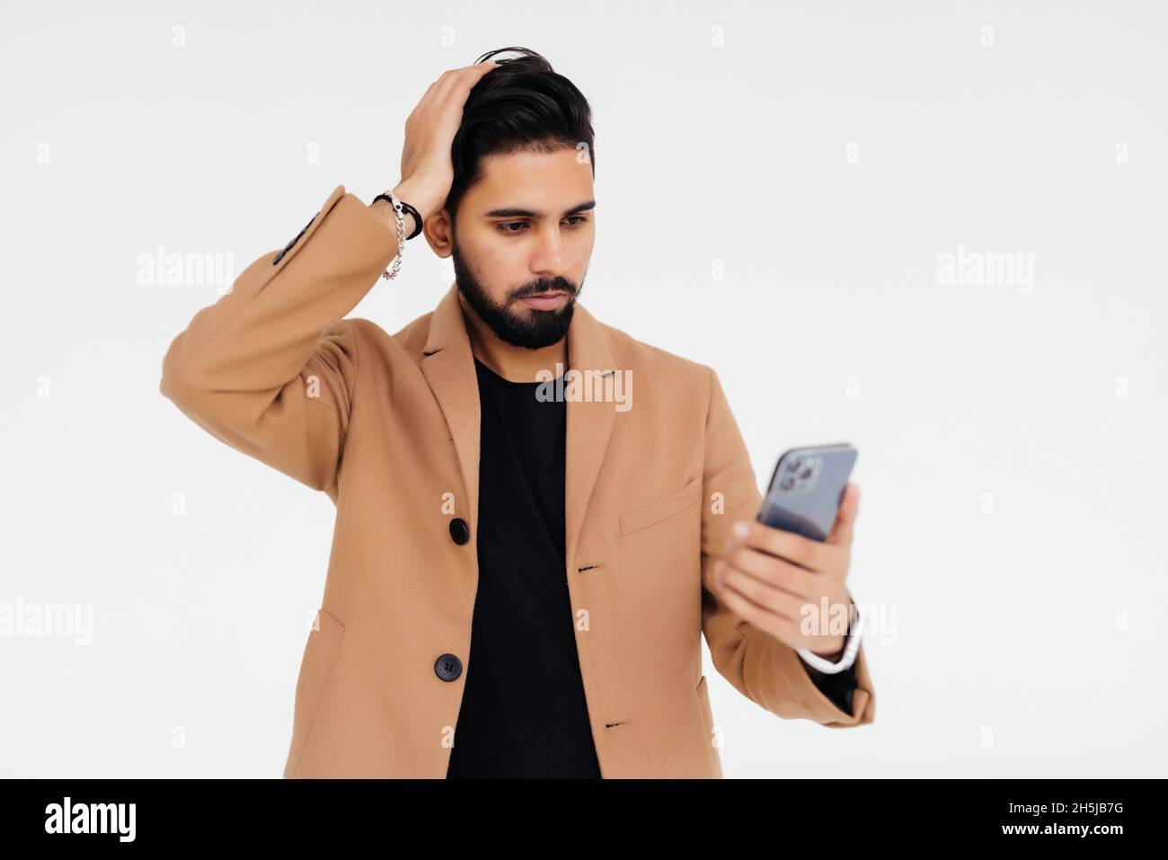 successful man looking upset on the phone isolated on a gray background ...