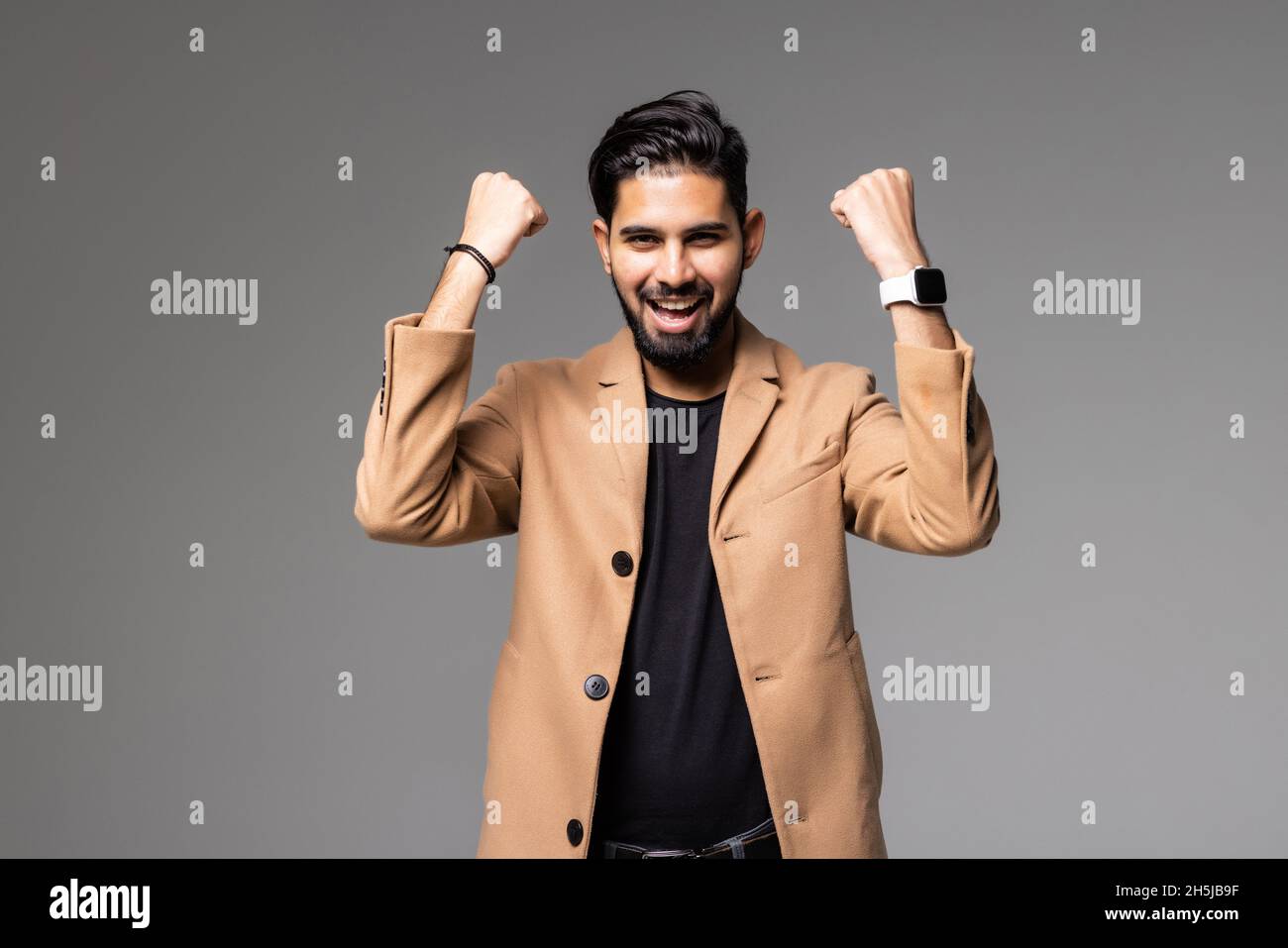 I made it to the top. Happy young man gesturing and smiling while ...