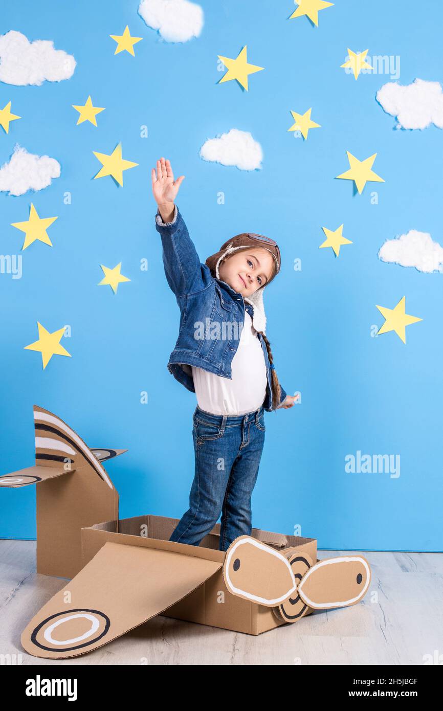 Little child girl in a pilot's costume is playing and dreaming of ...