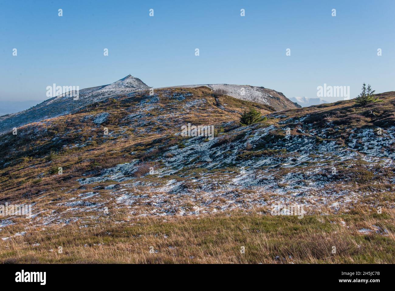 View of hills of Water Dividing ridge covered in dried grass and snow ...