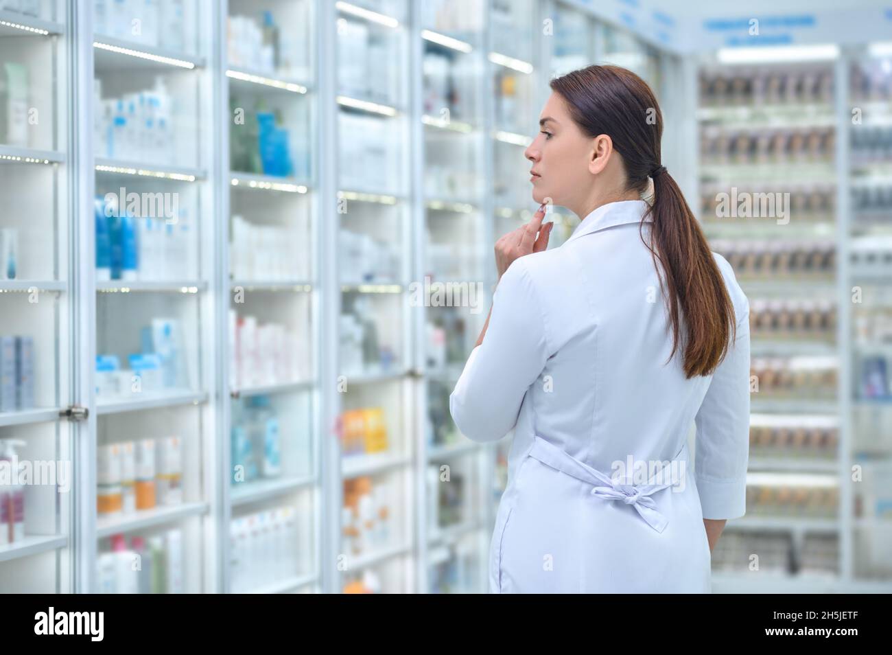 Back view of woman in white coat in pharmacy Stock Photo - Alamy