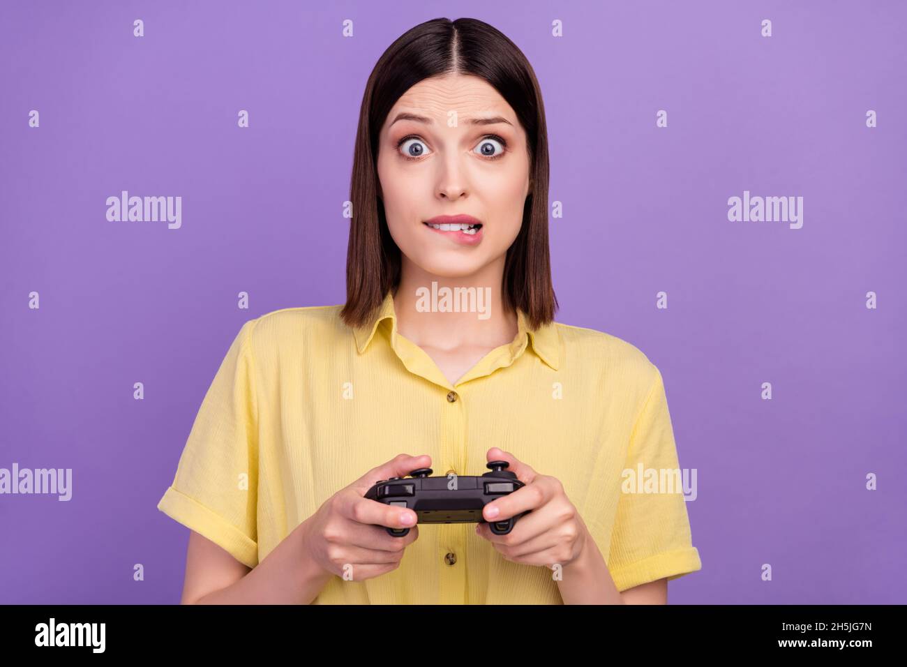 Photo of young woman afraid bite lips teeth play game station race ...
