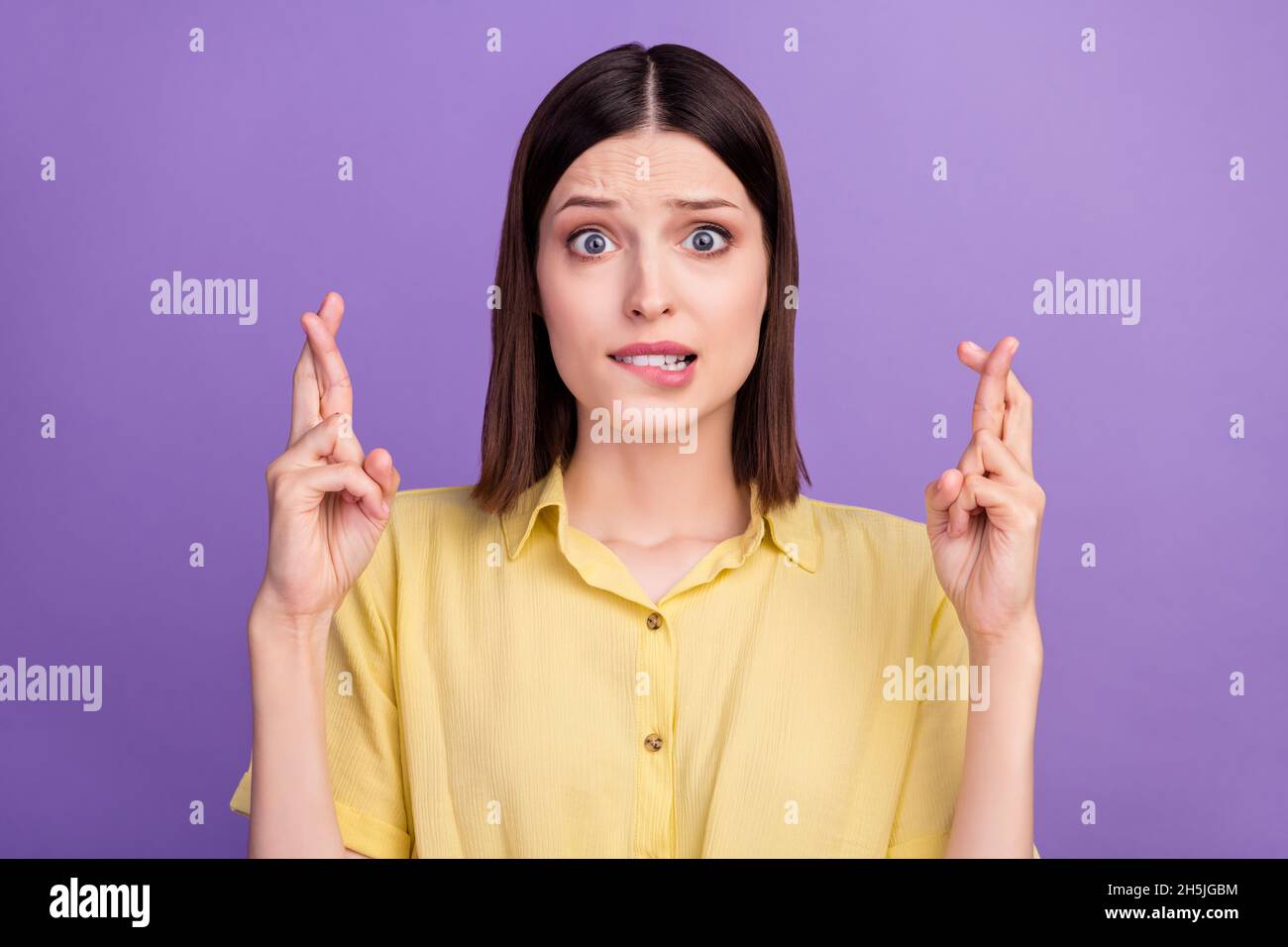 Photo of young girl bite lips teeth fear crossed fingers pleading wish ...