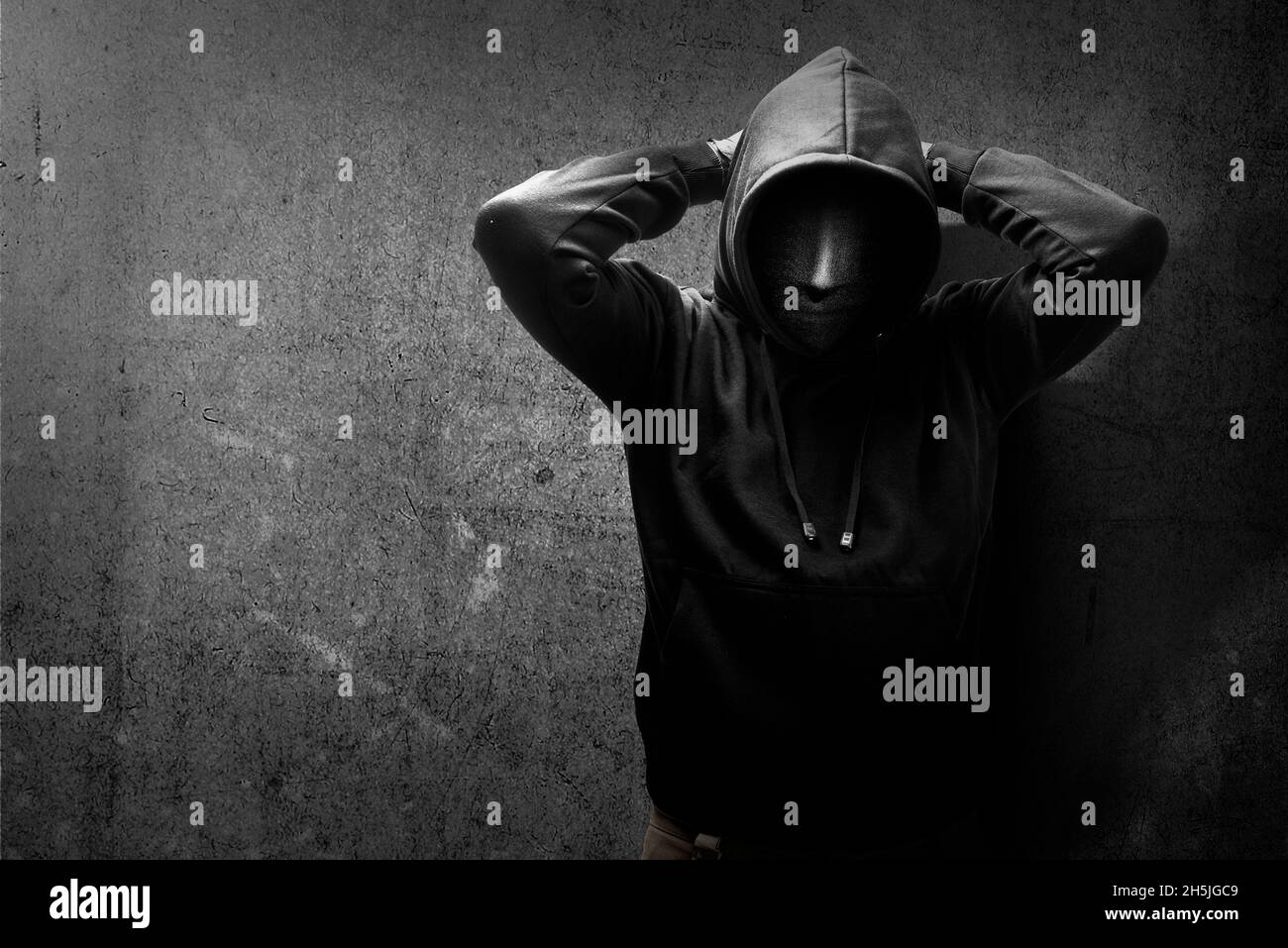 A criminal man in a hidden mask raised a hand behind the head for ...