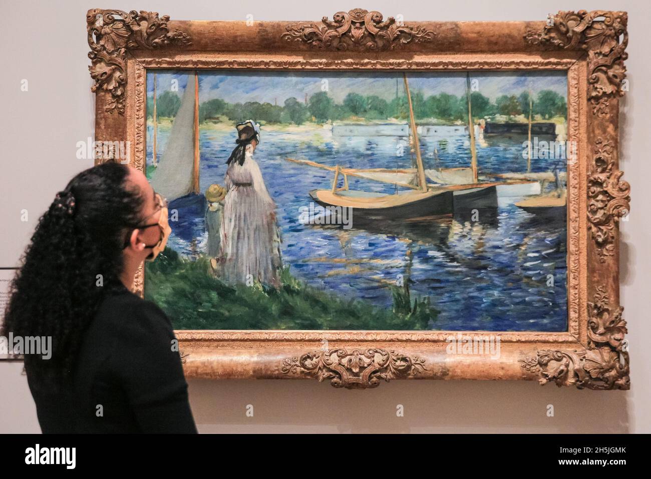 London, UK. 10th Nov, 2021. Gallery staff with Edouard Manet, The Seine at Argenteuil, 1874. The ...