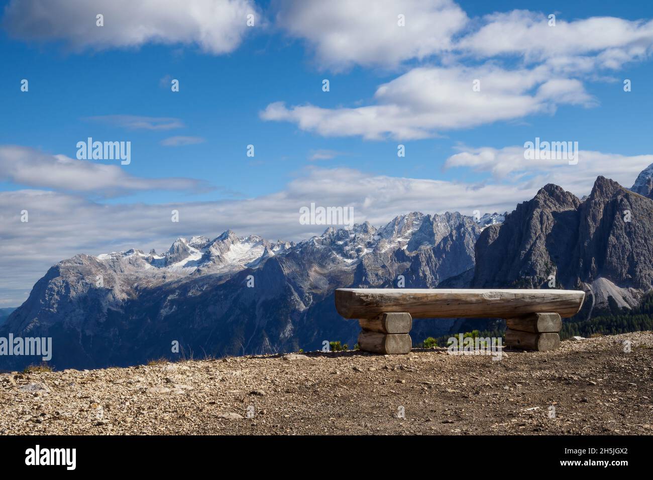 Wooden bench and in the background view of the mountain peaks. Belluno ...