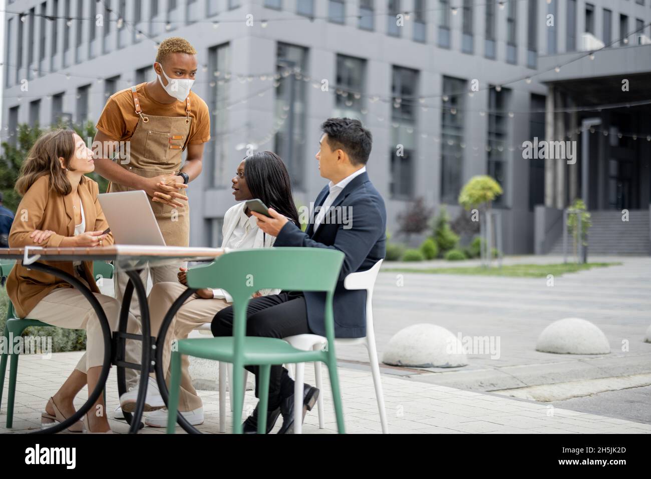 Waiter taking order from client at outdoor cafe Stock Photo - Alamy